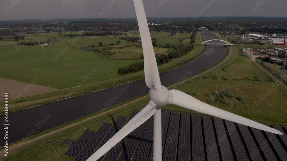 Closeup aerial of wind turbine blades and solar panels in The ...