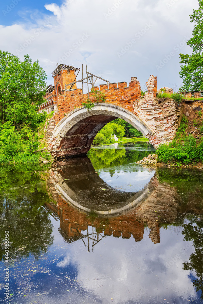 Old stone bridge arch with reflection in water, ruined historic ...