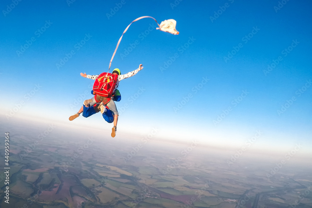 Skydiving tandem in a free fall. Tandem instructor release a pilot ...