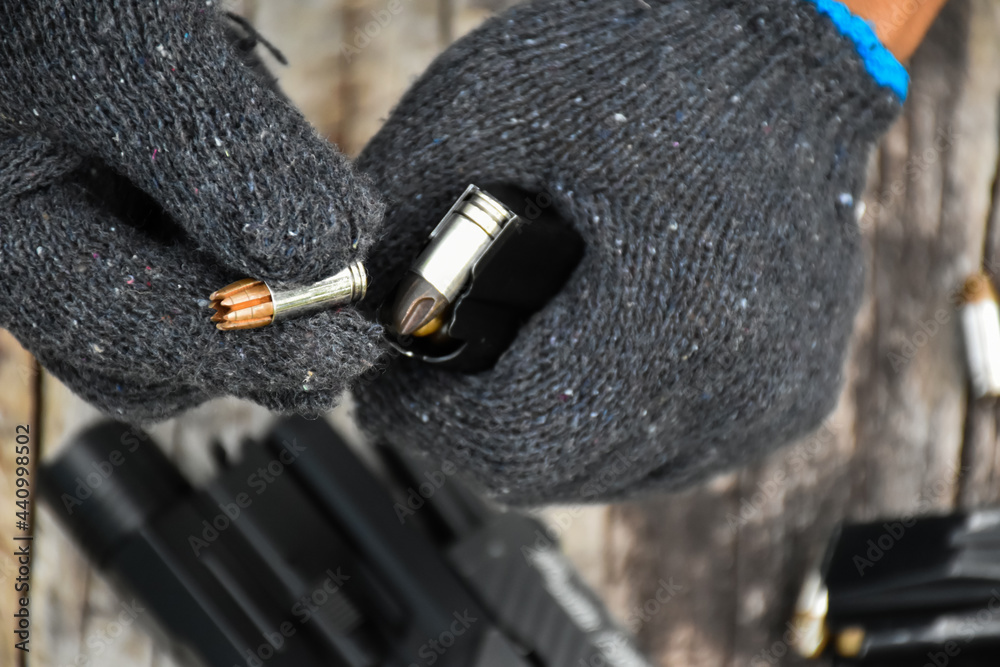 Photo & Art Print Two hands reloading 9mm bullets full metal jacket ...