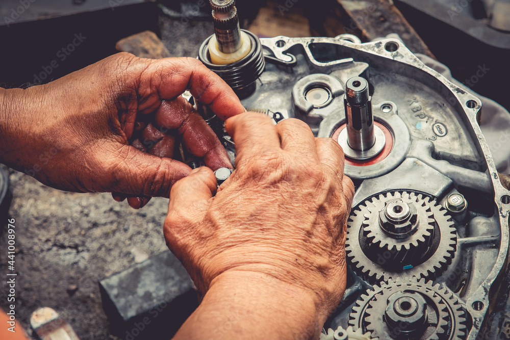 Motorcycle mechanics are assembling the motorcycle engine clutch ...