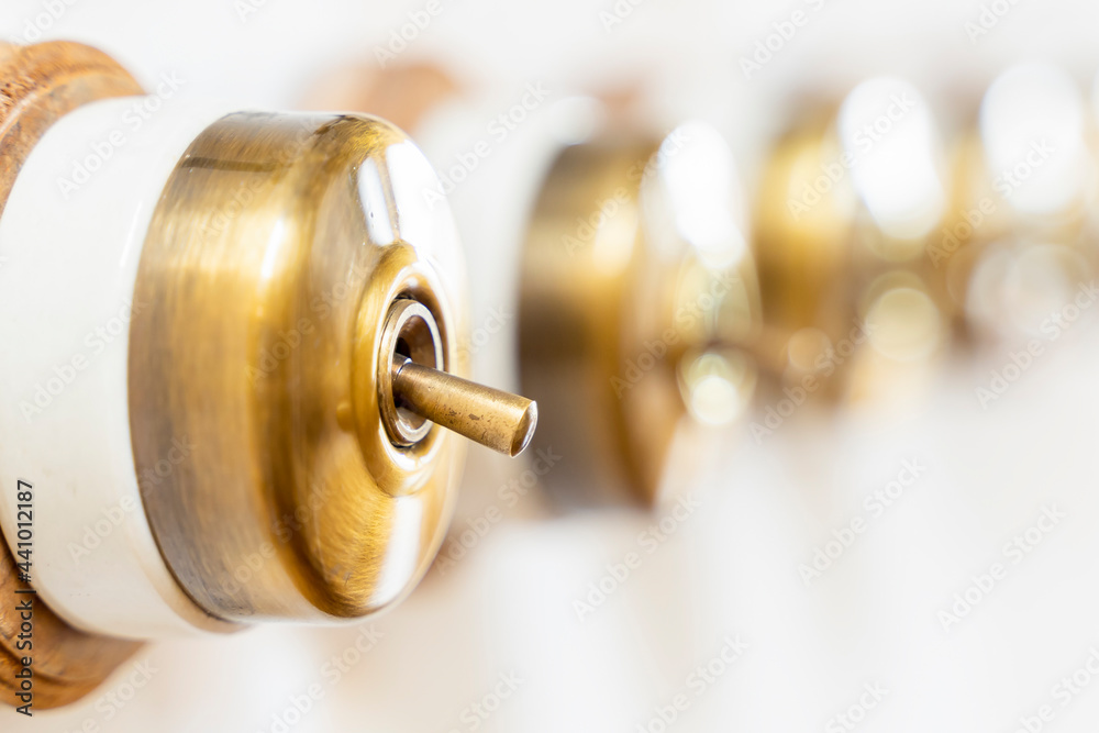 Retro style brass power switches on white wall. Brass vintage switch on ...