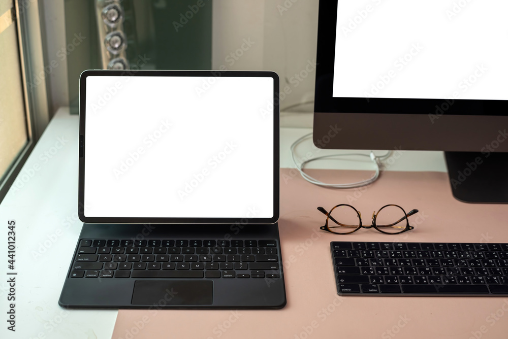Workspace. Tablet blank white screen and computer placed at the office ...