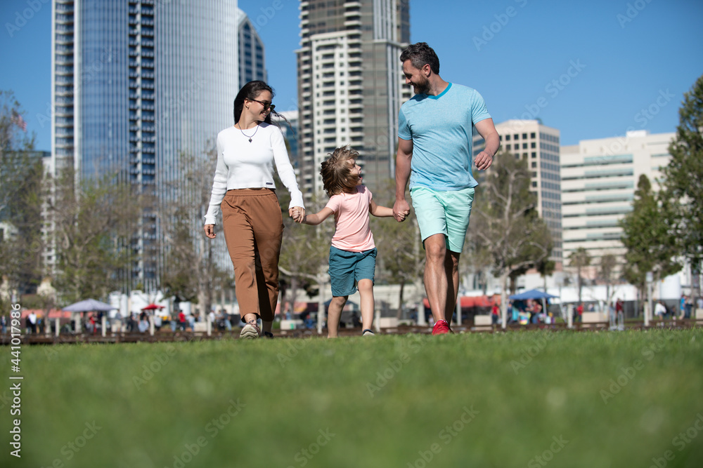 Parents with son walking in the city. Family taking a walk on street in ...