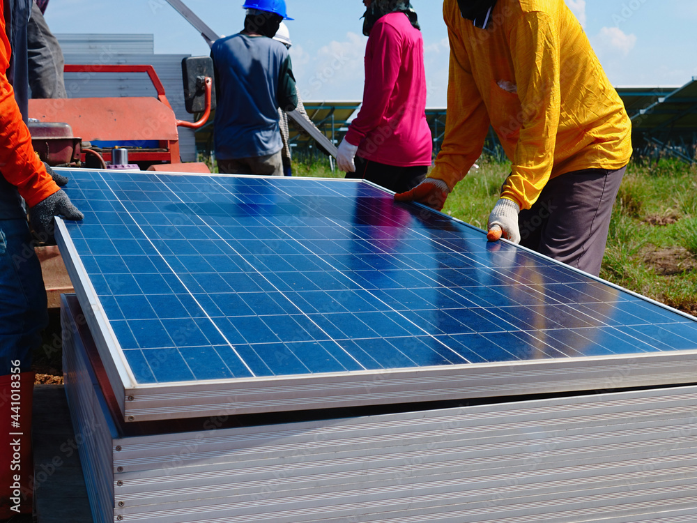 Workers are moving solar panels to install and generate electricity ...