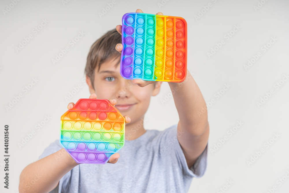 Boy holding sensory pop it fidget toys in his hands. Push pop-it ...