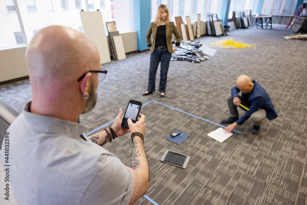 Man taking photo of architect laying out floor plan in office Stock ...