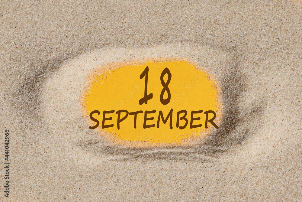 September 18. 18th day of the month, calendar date. Hole in sand ...
