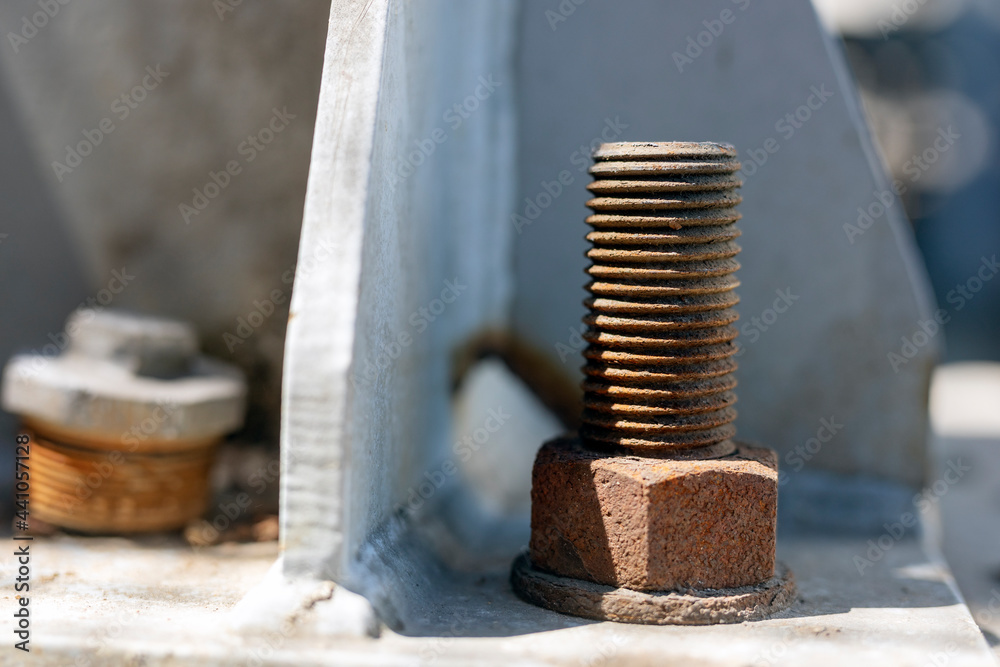 A rusty steel anchor bolt on the flange of the structure steel. Anchor ...