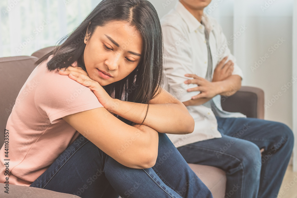 Unhappy young asian couple fights on couch, relationship is in trouble ...