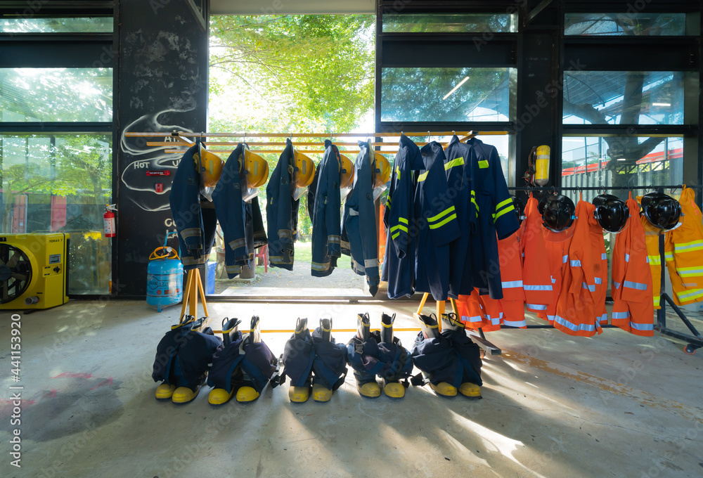 Firefighting or fireman clothes on rack at fire station storage, an ...