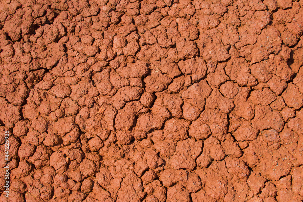 The surface of red clay, covered with cracks. The surface looks like ...