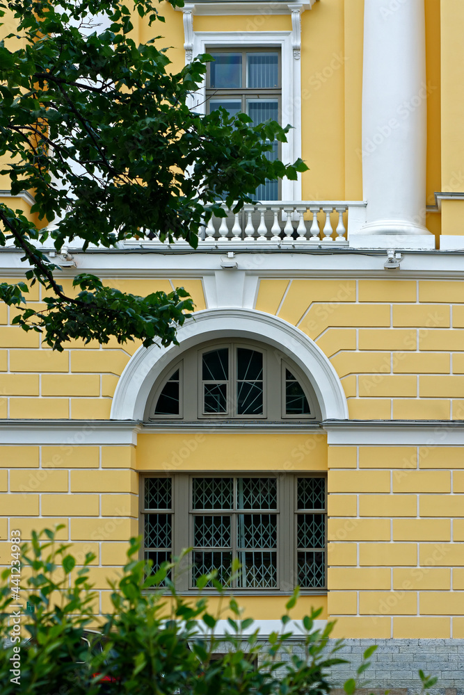 Arched window and a rectangular window with a balcony and white columns ...