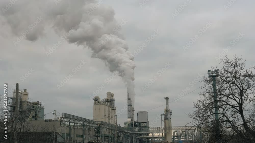 Factory chimney. Puffs of smoke coming out of a tall smokestack in a ...