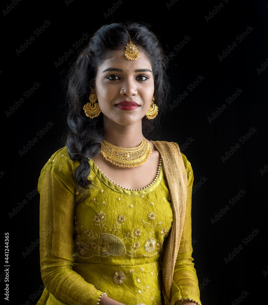 Portrait of beautiful traditional Indian girl posing on black ...