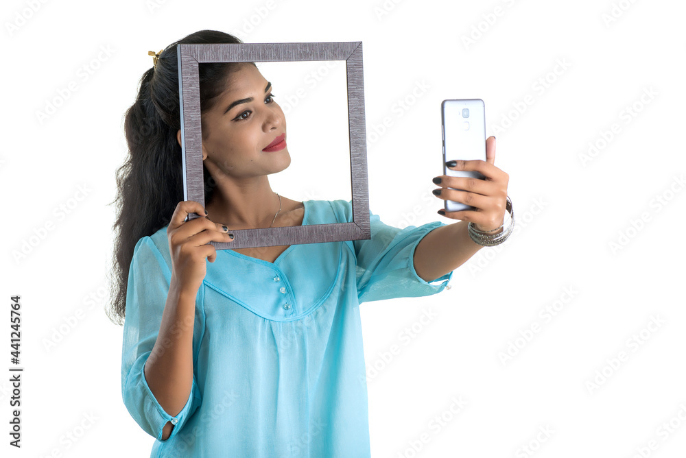 Young Indian girl using a mobile phone or smartphone with photo frame ...