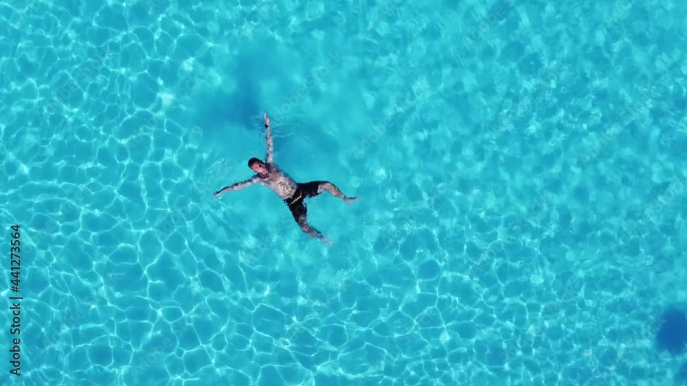 Man swims backstroke at swimming pool. Rippling water in swimming pool ...