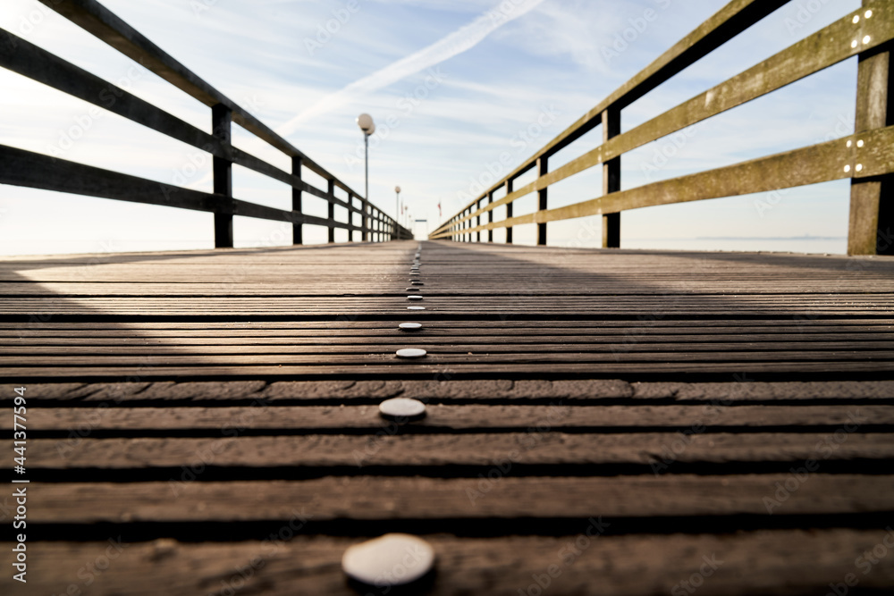 Foto de Ground view over an empty wooden pier with nails and a railing ...
