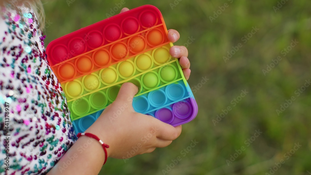 Child kid play with pop it sensory toy, hands close-up. Girl presses on ...