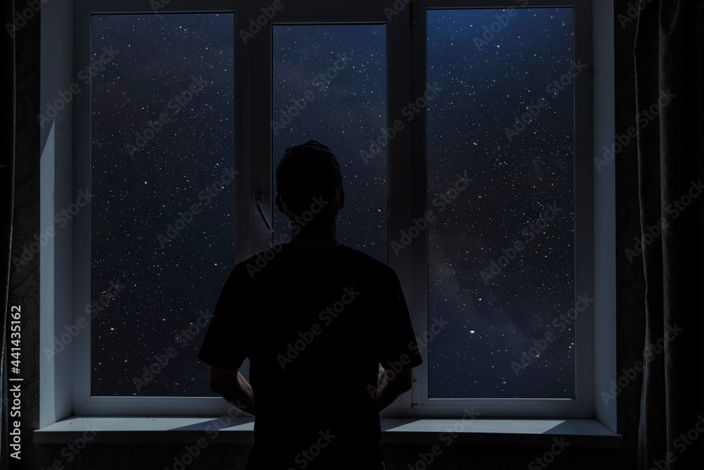 person standing next to the window and watching outside, admire the ...