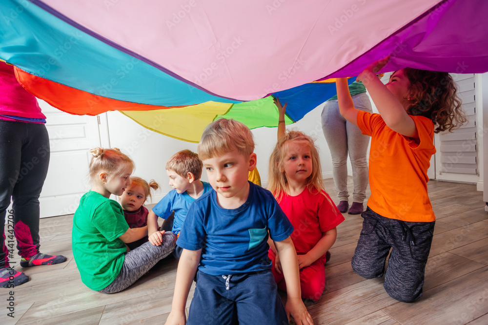 Organised team building games for kids using rainbow canopy Stock Photo ...