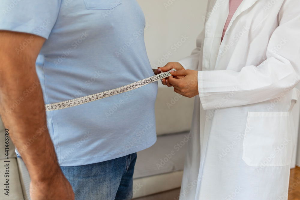 Cropped shot of a female doctor taking obese patient's body fat ...