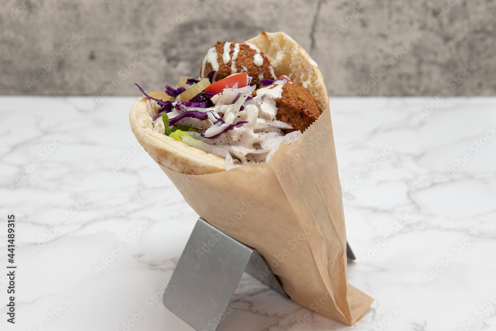 Pita wrap sandwich loaded with meat, bite size falafels, and vegetable ...