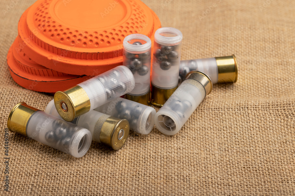 Clay shooting target with shotgun shell on sackcloth background , Clay ...