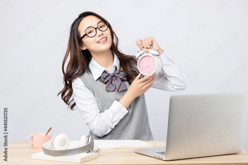Beautiful college student girl taking online class on gray background ...