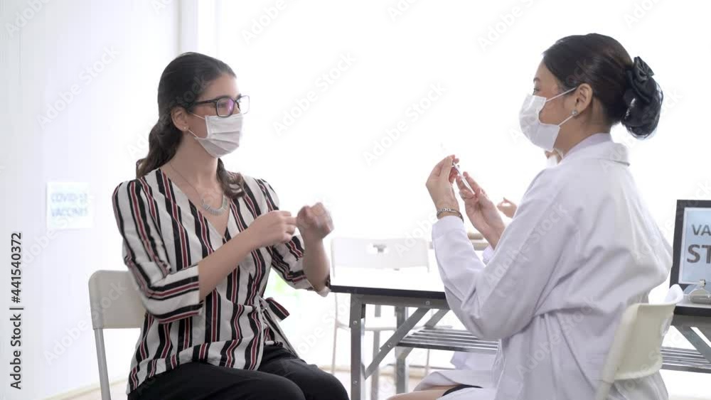 Vidéo Stock woman sitting on a chair to getting vaccine in clinic or ...