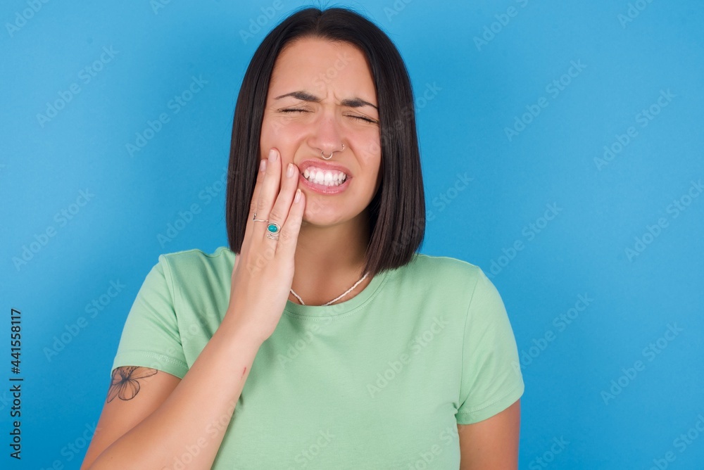 young beautiful brunette girl with short hair standing against blue ...