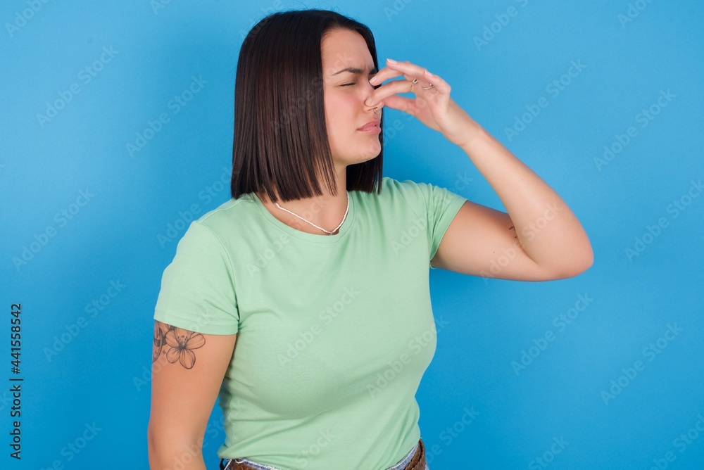 young beautiful brunette girl with short hair standing against blue ...