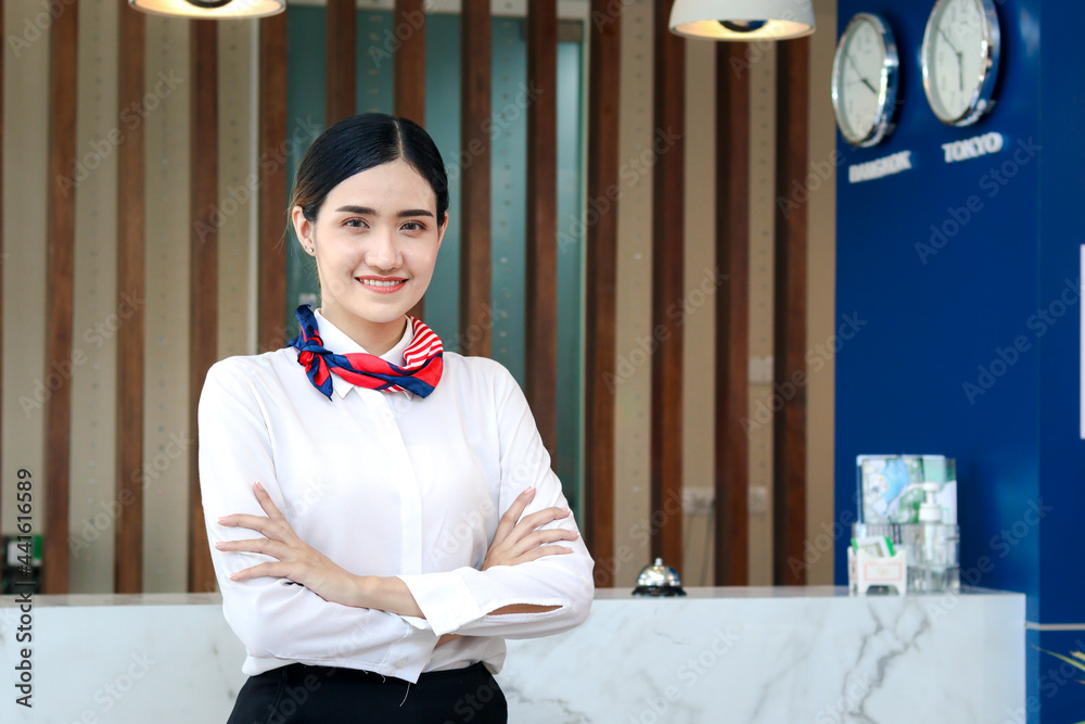 Portrait of smiling young beautiful Asian female receptionist ...