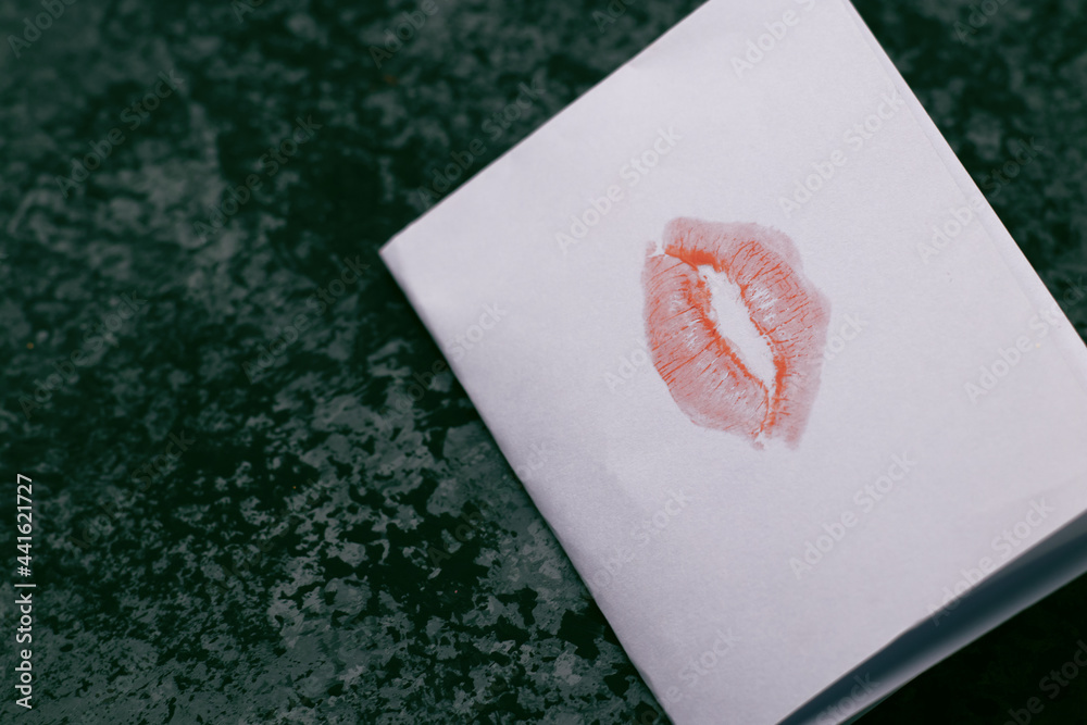 Love letter with a print of lips made by pink lipstick on the textured ...