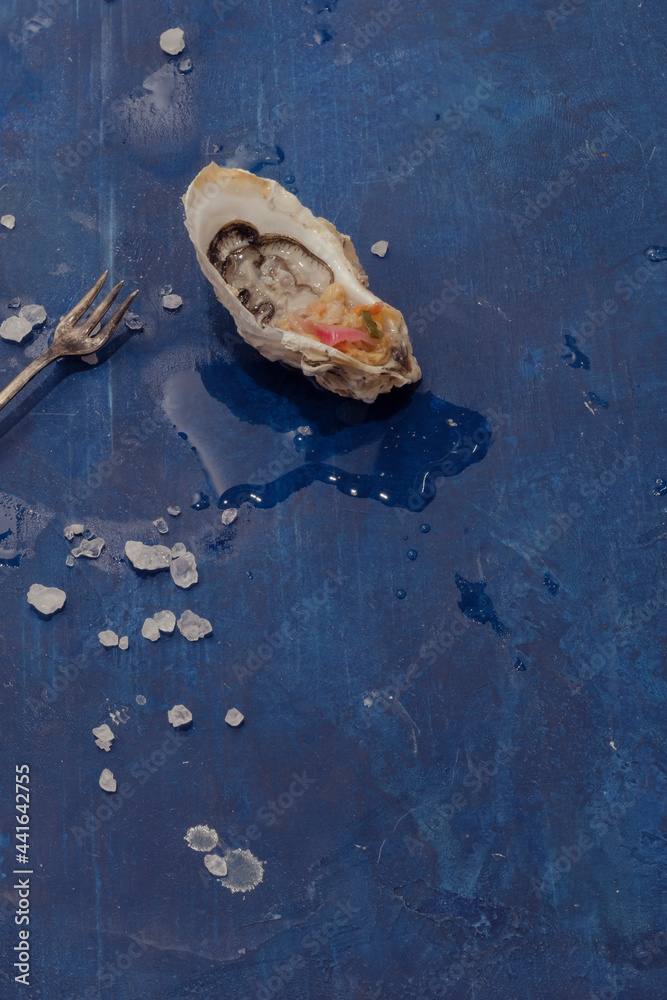 Single oyster with oyster fork and spicy pickled slaw Stock Photo ...