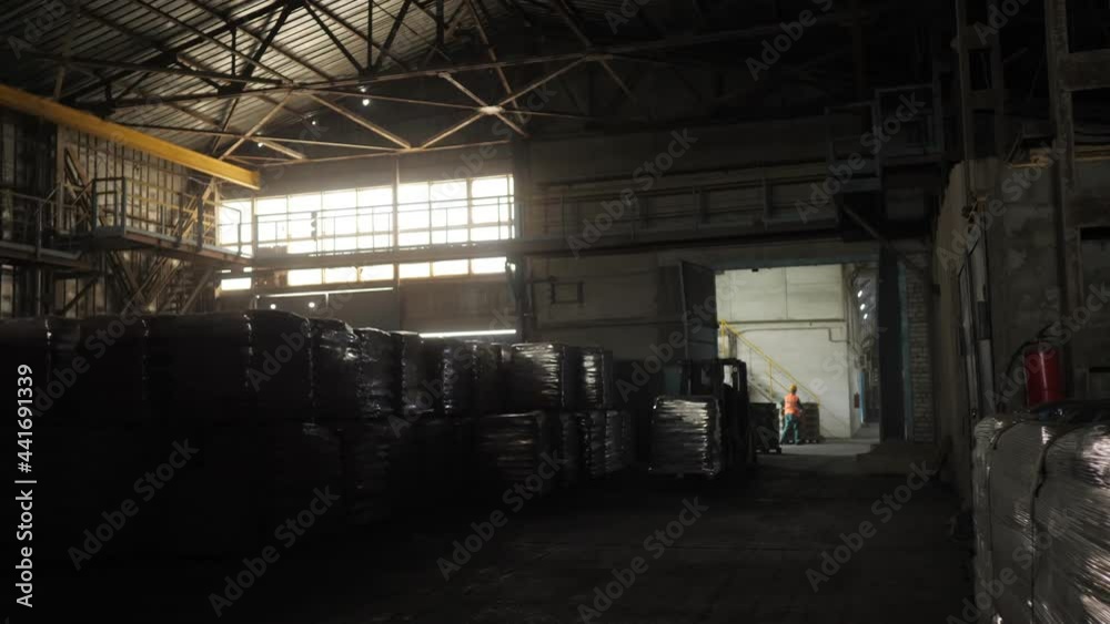 The loader driver loads and unloads pallets with bags in a very dark ...