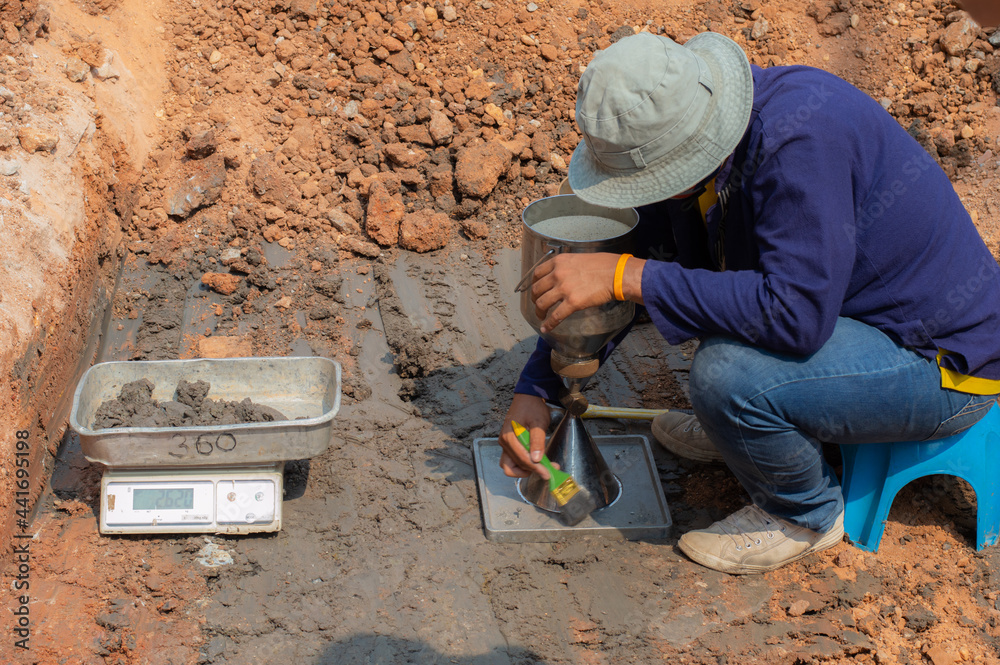 Worker using equipment for testing laboratory field density test sand ... Worker using equipment for testing laboratory field density test sand ...
