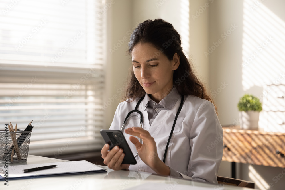 Foto Stock Caucasian female doctor in white medical uniform sit at desk ...