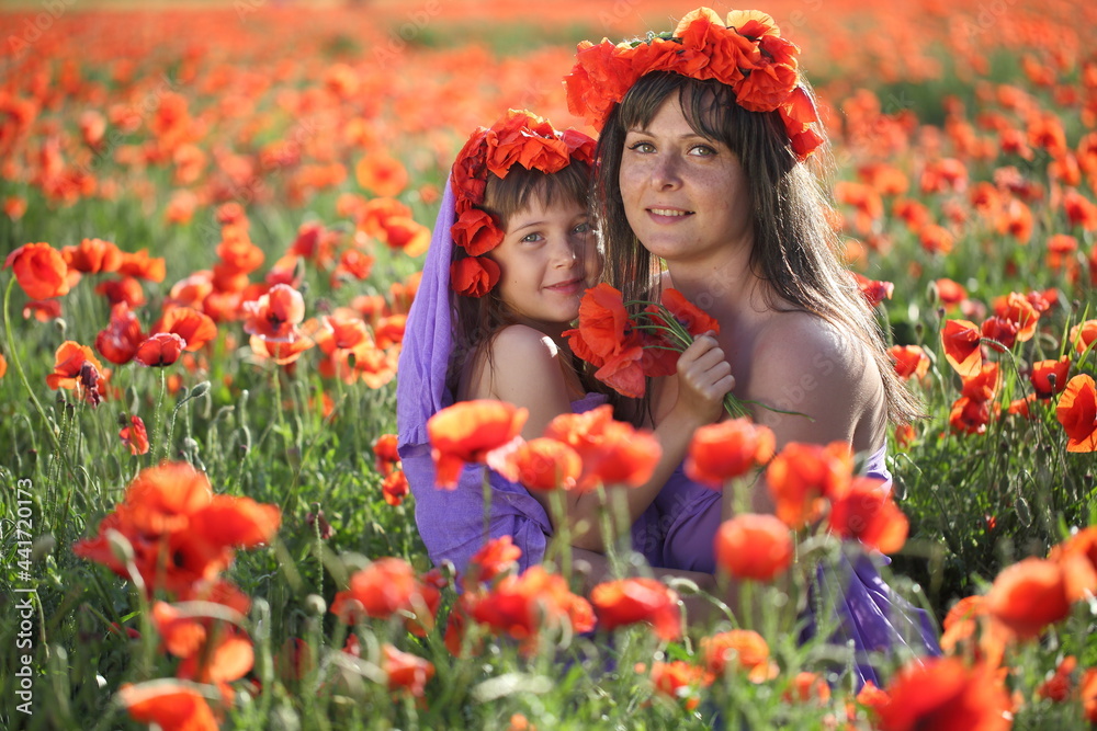 Mother and daughter are walking in a beautiful field of poppies Stock ...