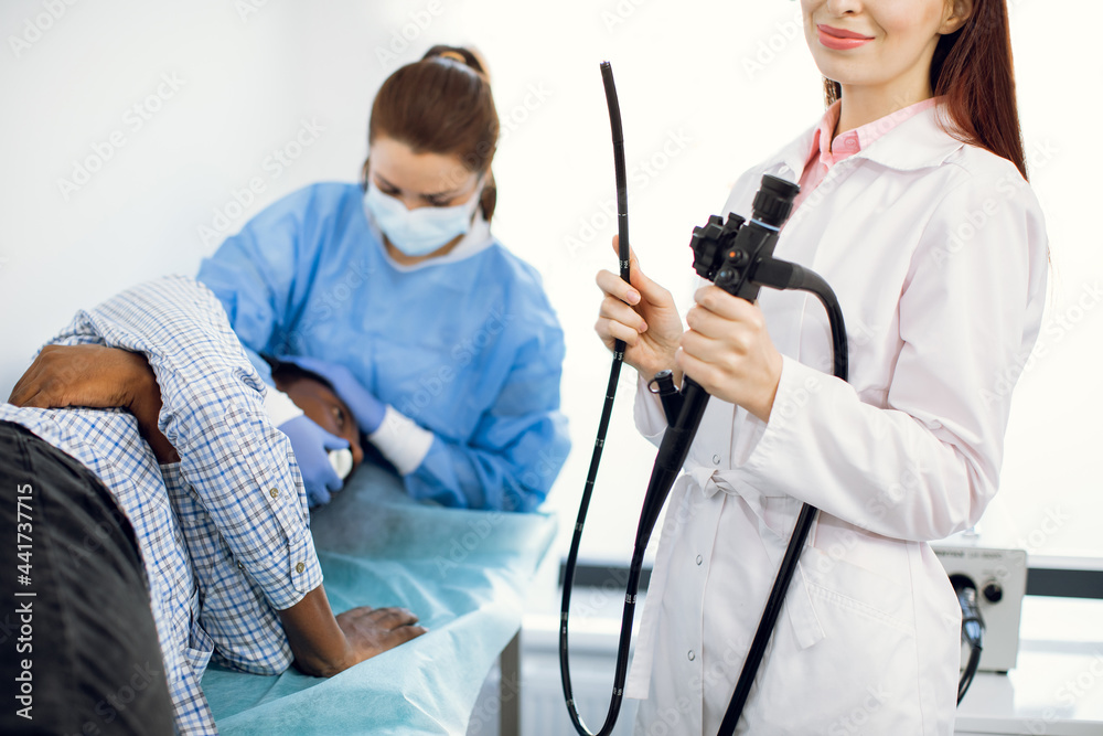 Cropped close up shot of female young doctor holding endoscope. Afro ...