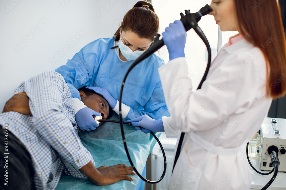 Male African patient having endoscopy in modern clinic. Two ...