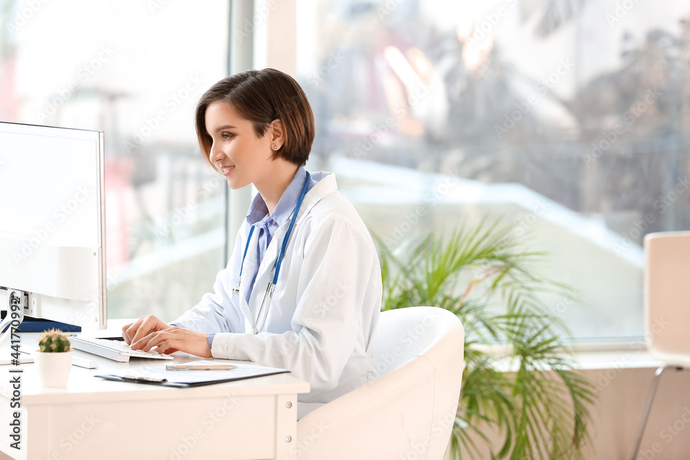 Female doctor working with computer in clinic Stock Photo | Adobe Stock