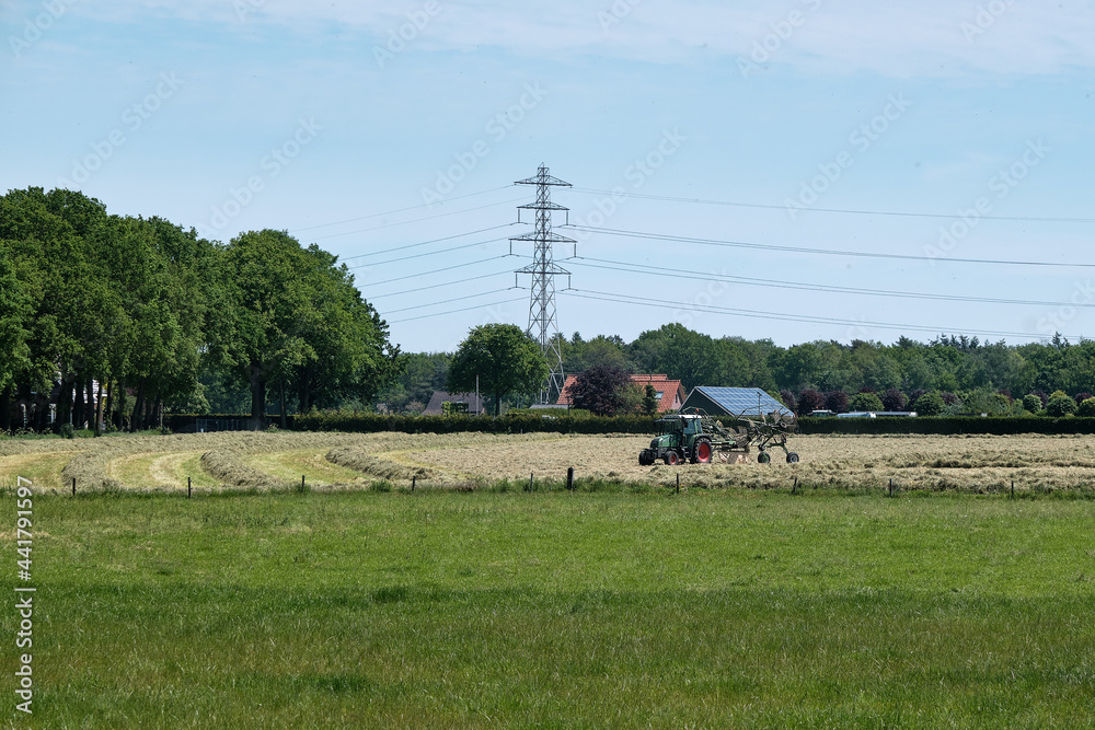 Dronten, the Netherlands June1,2021:Grassland with tractor mower and ...