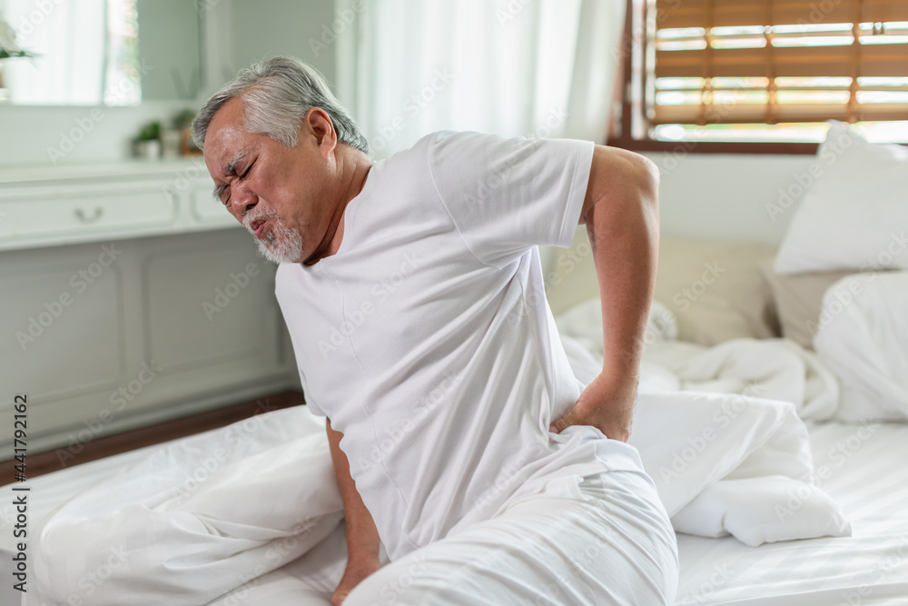 Asian Elderly senior man back pain and illness on bed at home,unhappy ...