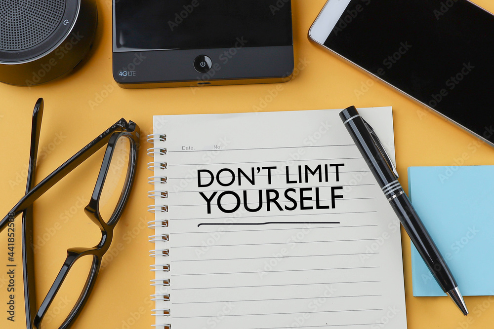 Motivational quote on Dont' Limit Yourself written on the notebook ...
