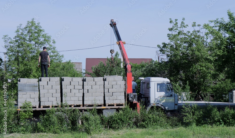 unloading of concrete blocks to the construction site using special ...