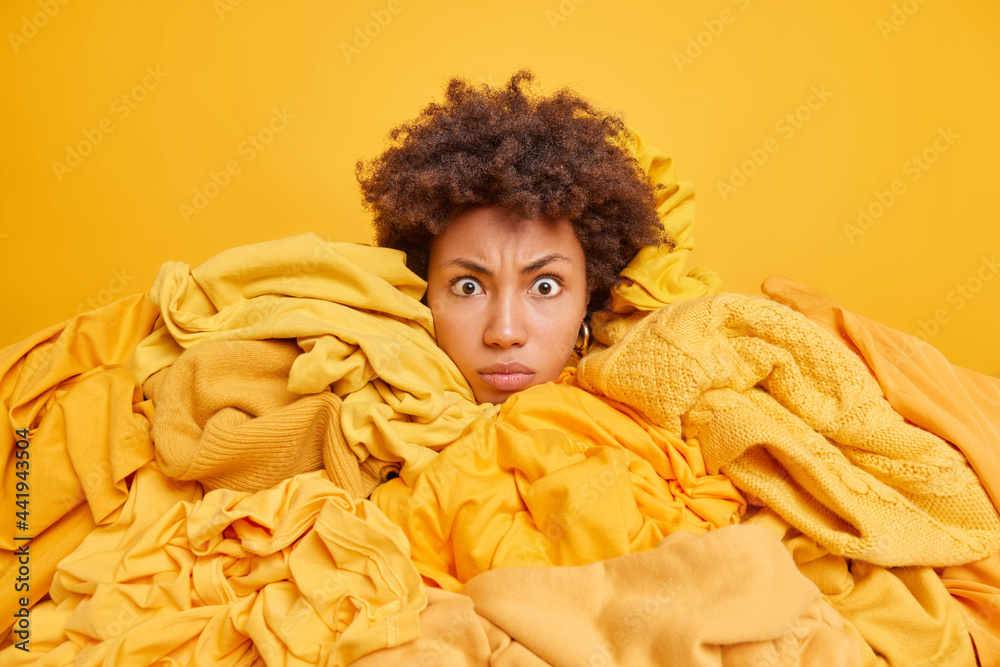 Serious curly haired Afro American woman looks shocked at camera ...