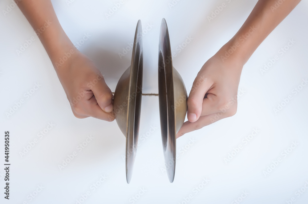 Hand holding cymbals, an old Thai musical instrument isolated on white ...