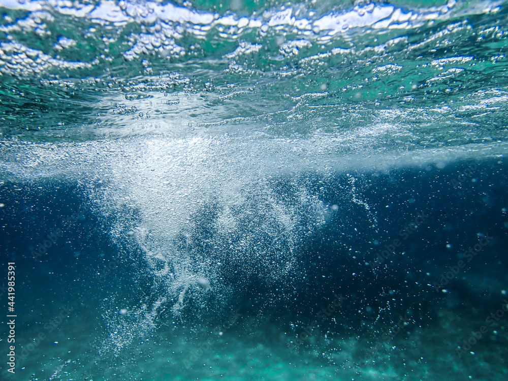 Bubbles under the sea in the crystal clear green sea water ...
