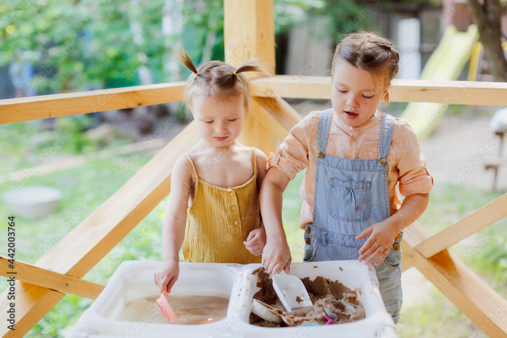 Happy children play with sand and water in sensory baskets on the ...